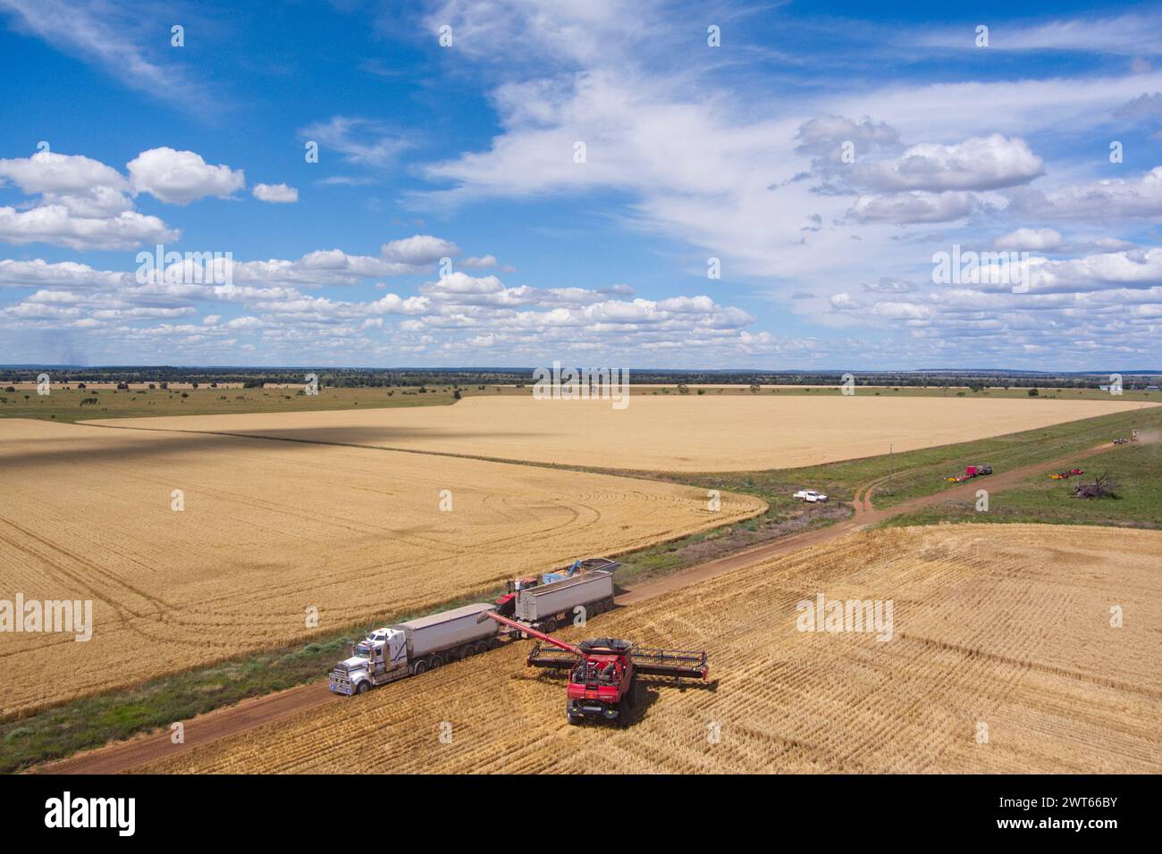 Aerial of combine harvester unloading harvested grain to truck ...