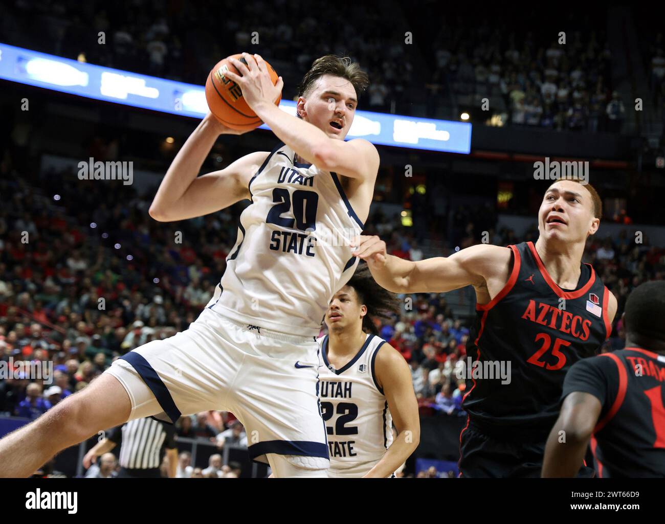 Utah State center Isaac Johnson (20) grabs a rebound next to San Diego ...