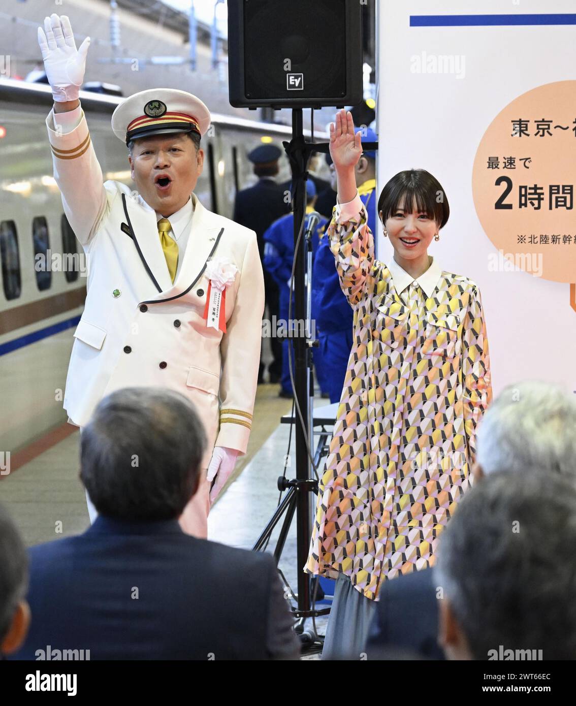 Actress Minami Hamabe (R) gestures prior to the departure of the first train bound for Tsuruga ...