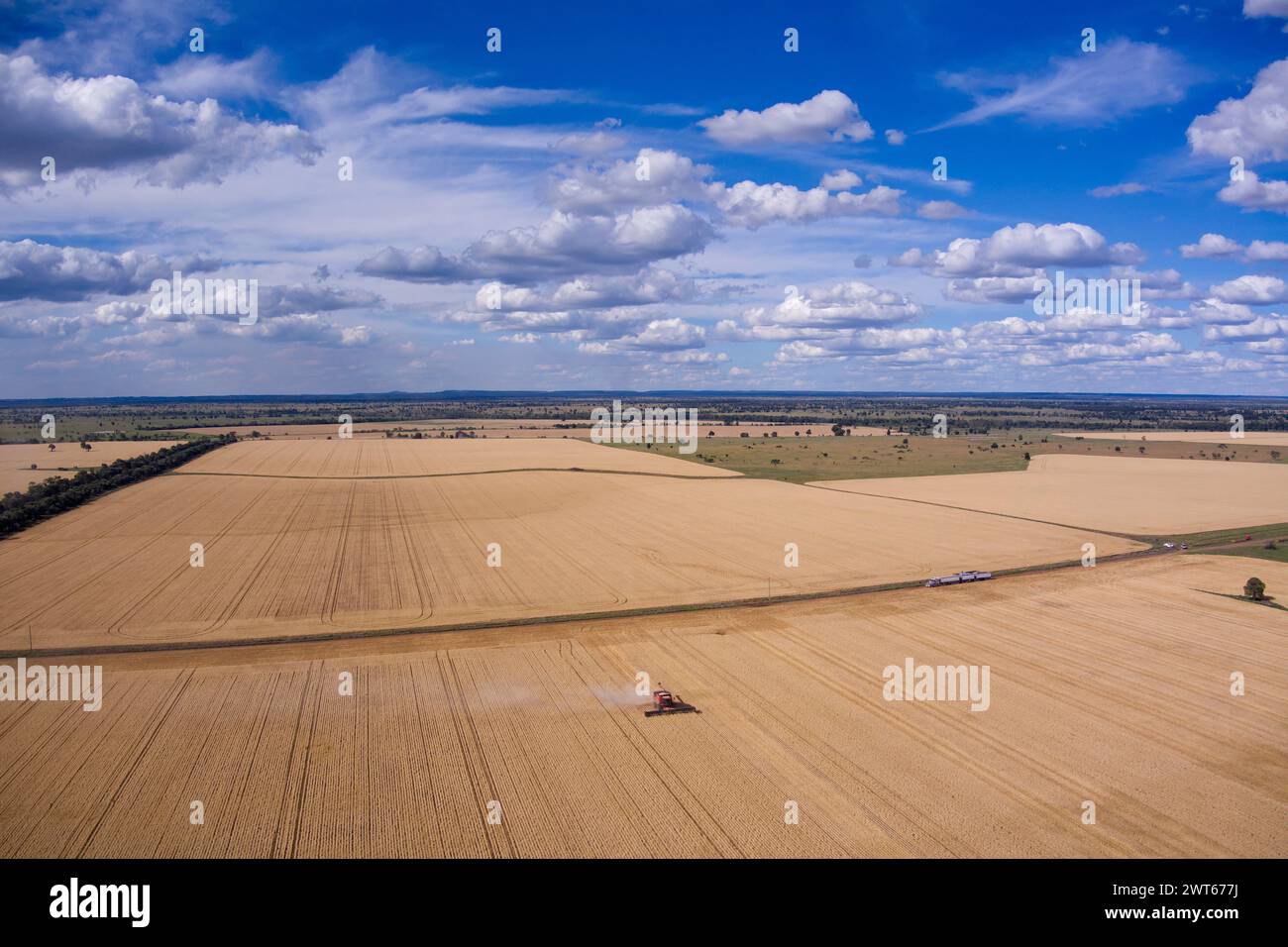 Aerial of combine harvester unloading into a bin chaser harvested wheat ...