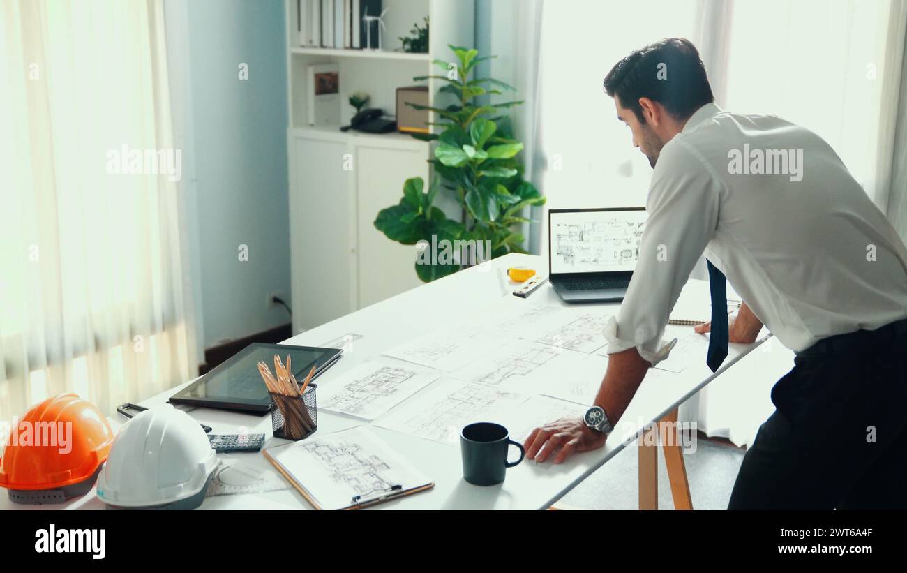 Smart engineer standing and writing idea at blueprint and laptop ...