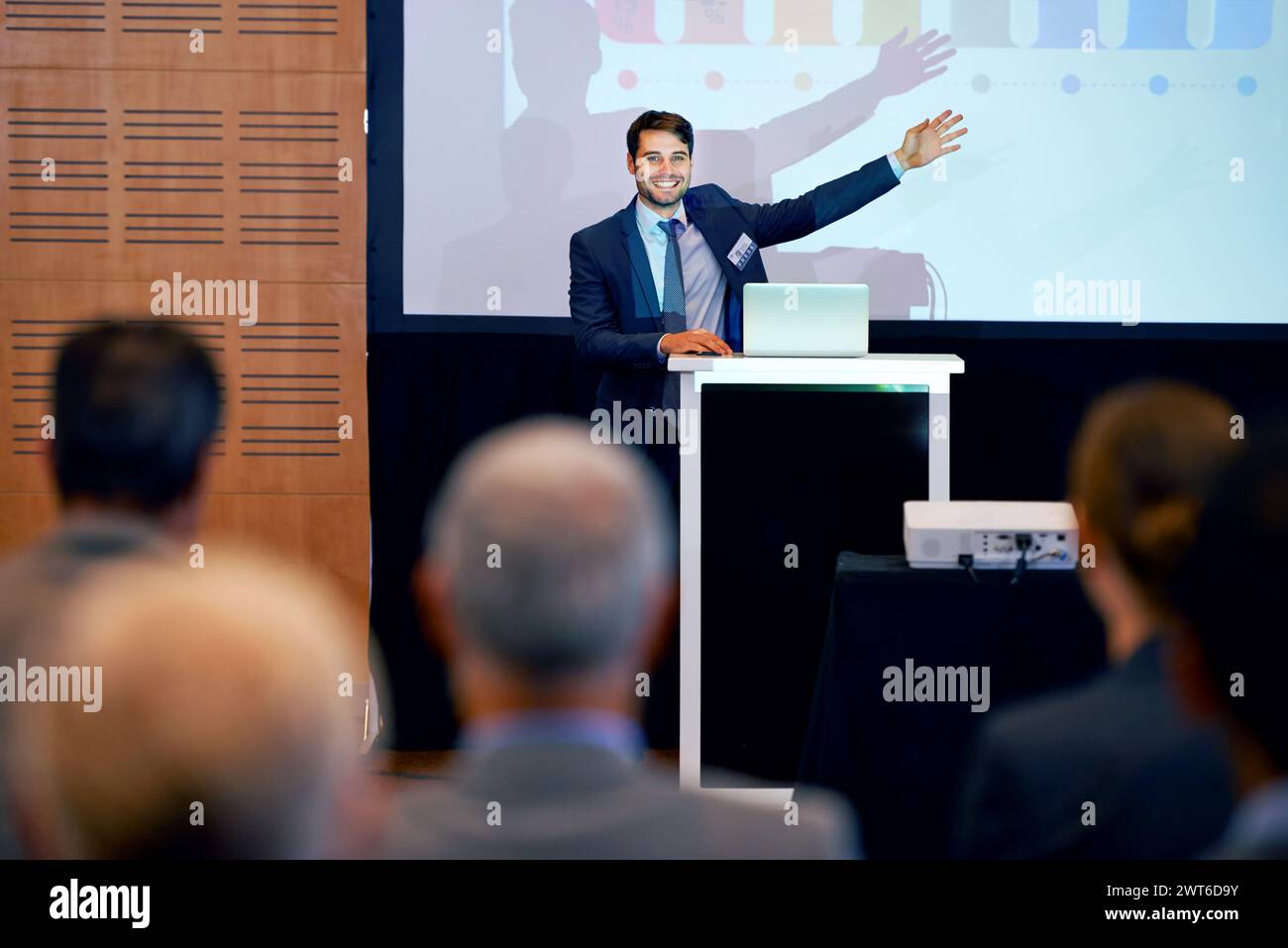 Business man, podium and presentation, pointing at projector screen at ...