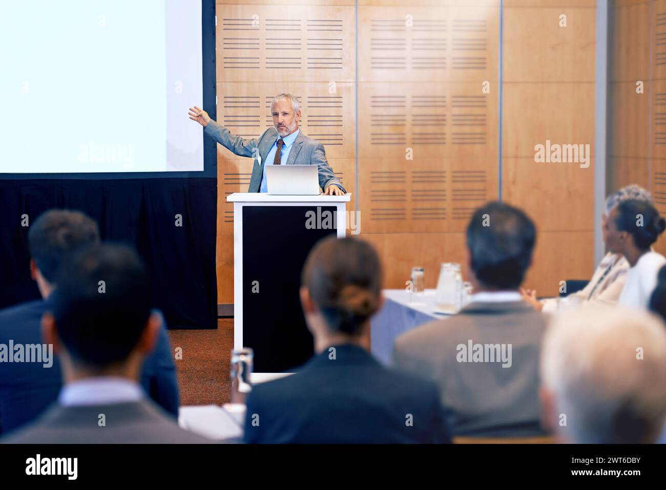 Senior, businessman and spokesperson with presentation on projector for ...