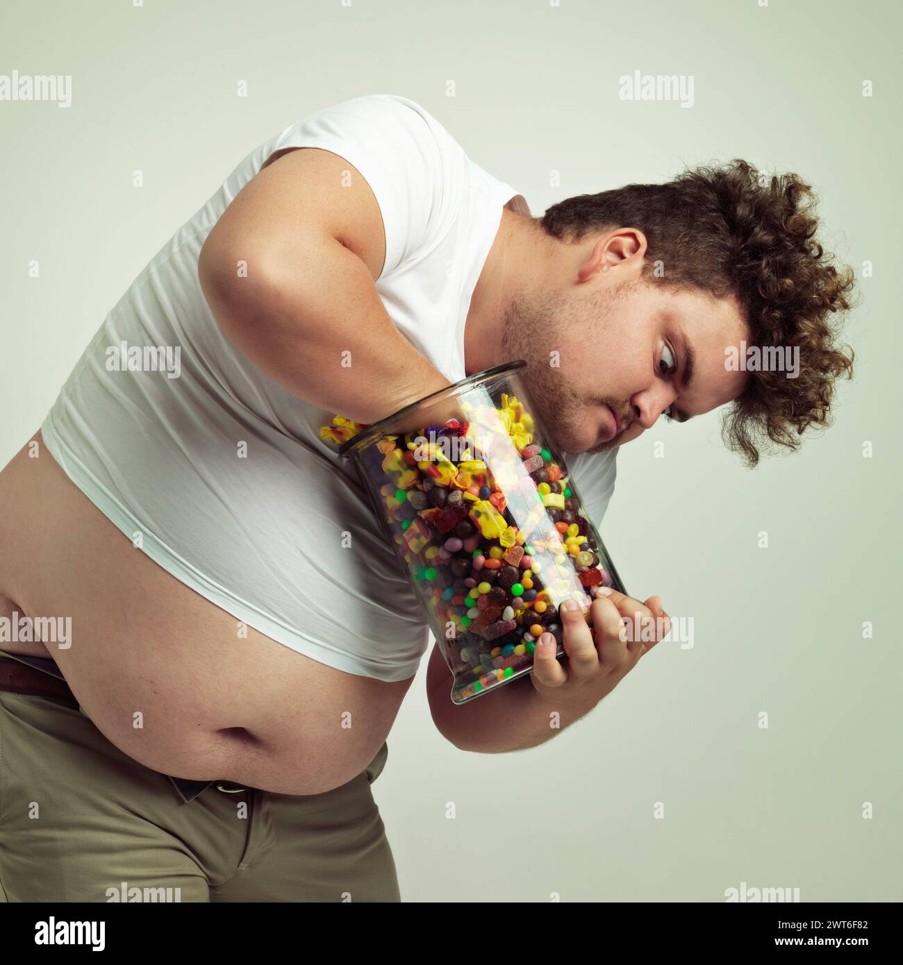 Candy, jar and man in on studio background crazy for luxury snack ...