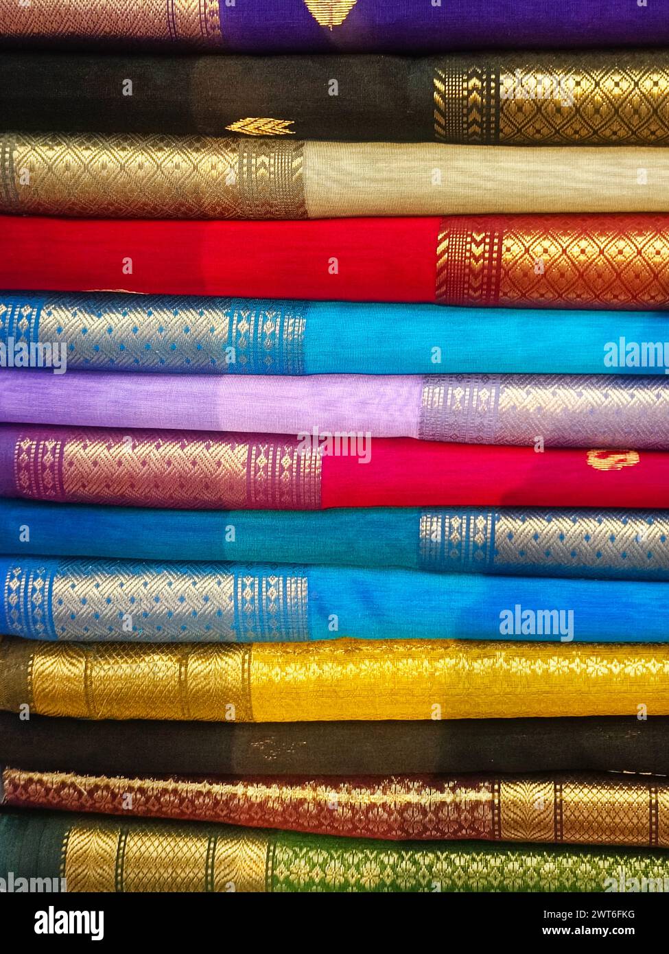 Closeup view of stacked saris or sarees in display of retail shop, for ...