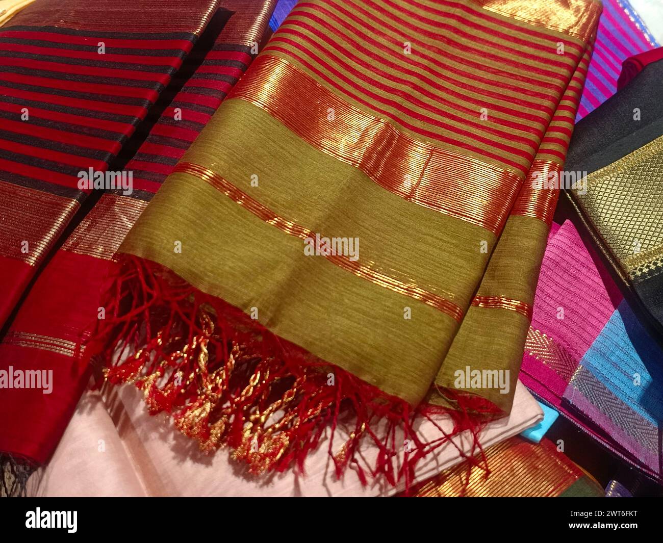 Closeup view of stacked saris or sarees in display of retail shop, for ...