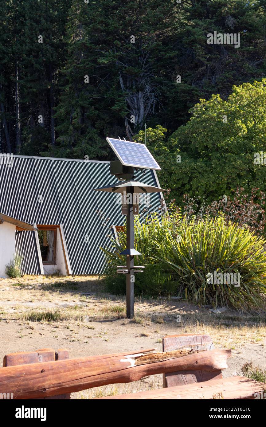 One solar panel in a pole near a modern house in the middle of a forest ...