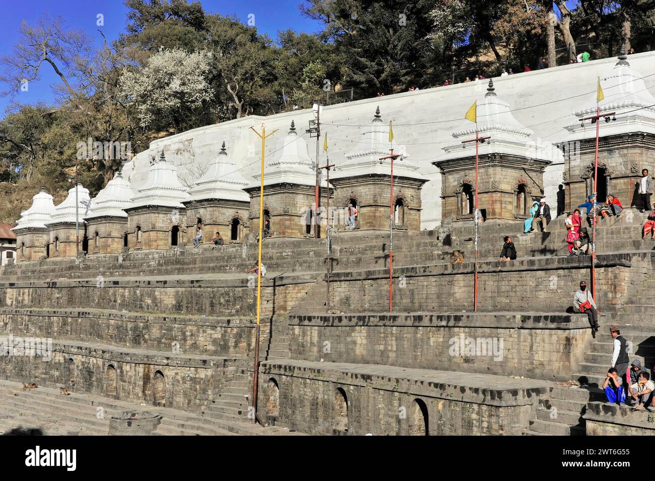 People sitting and walking on the steps of a historic temple complex ...