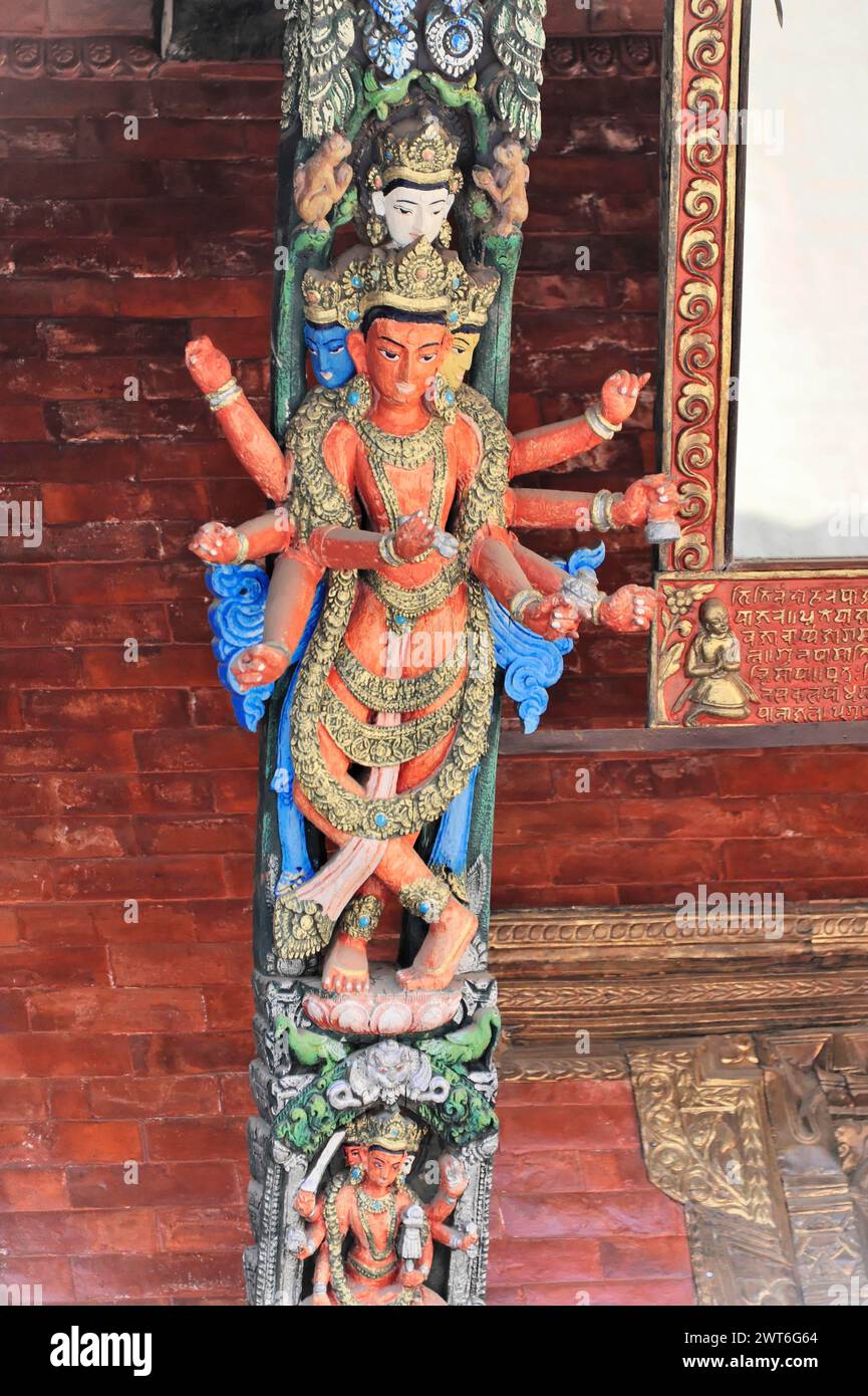 Colourful wood carving of a multi-armed deity in traditional Nepalese ...