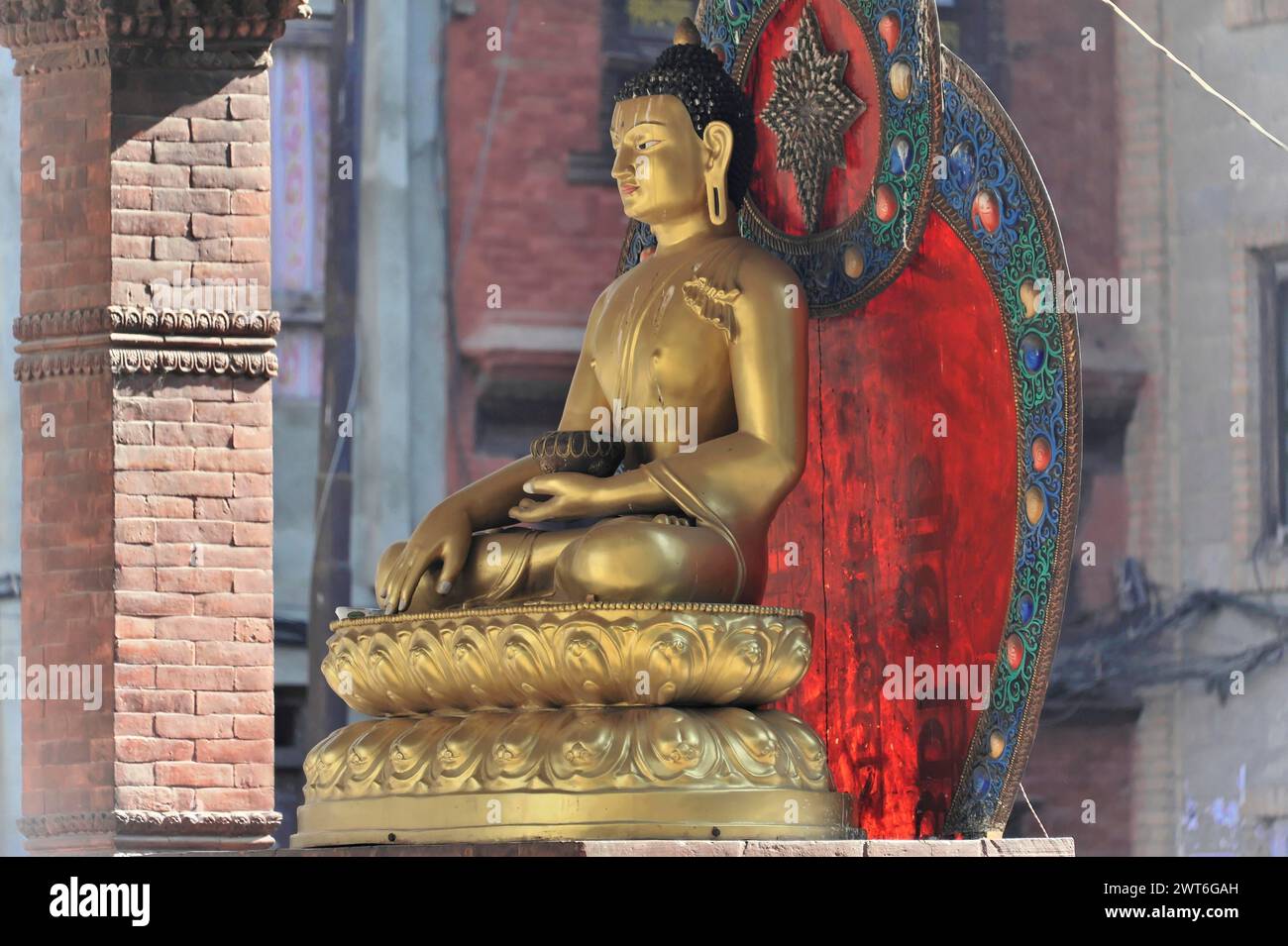 Calm looking golden Buddha statue in front of a blue mandala in ...