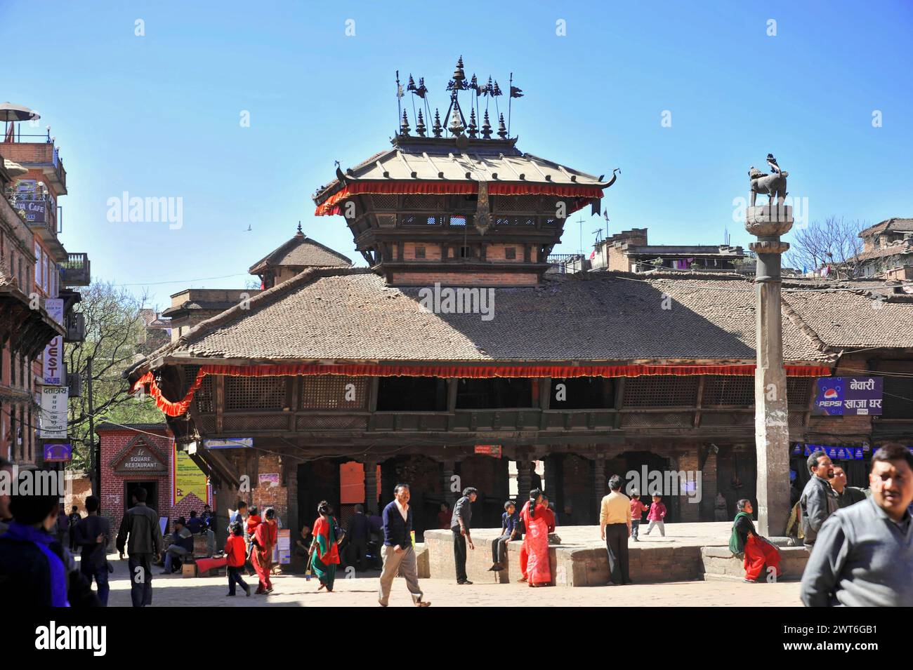 Lively square in front of a traditional temple under a blue sky ...