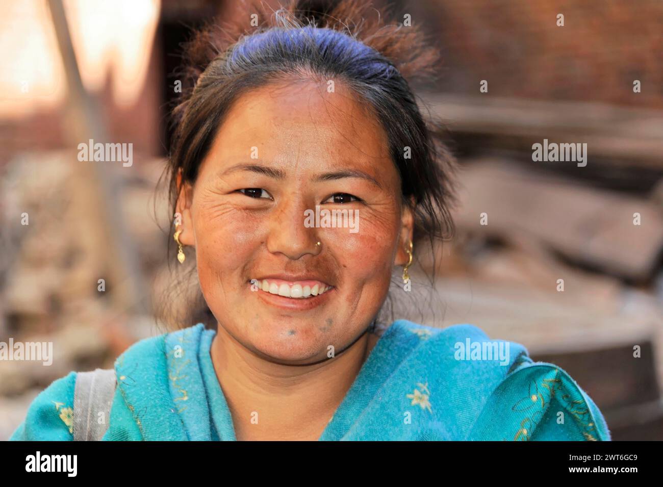 A smiling woman in traditional blue clothing with earrings, Kathmandu ...