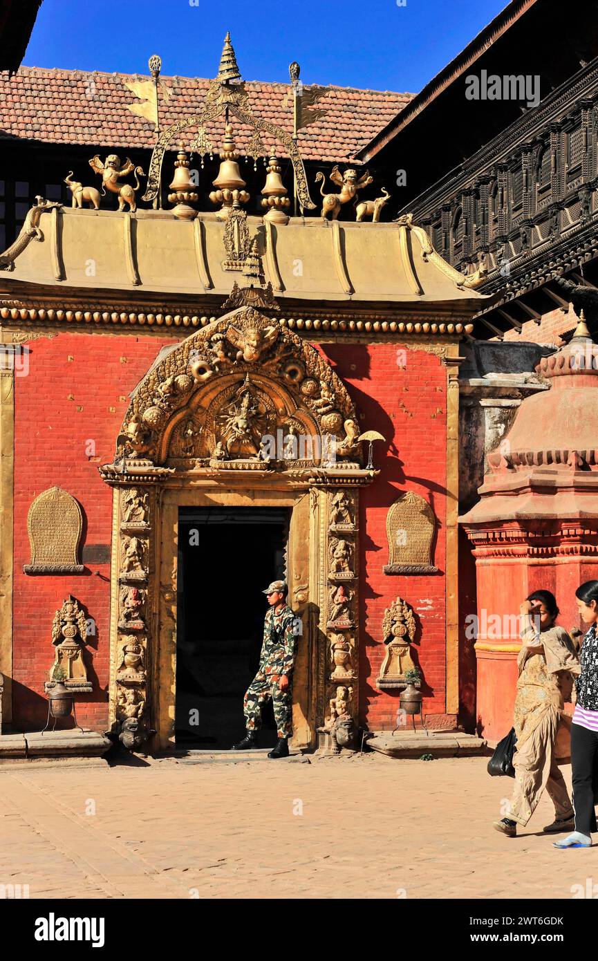 People walking through the decorated gate of a temple, Kathmandu Valley ...