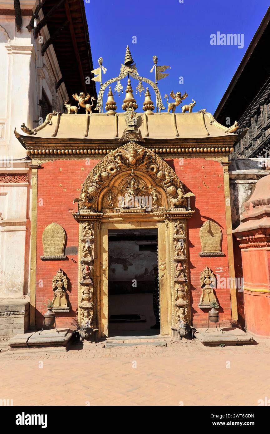 Golden gate of a Nepalese temple with traditional sculptures under a ...