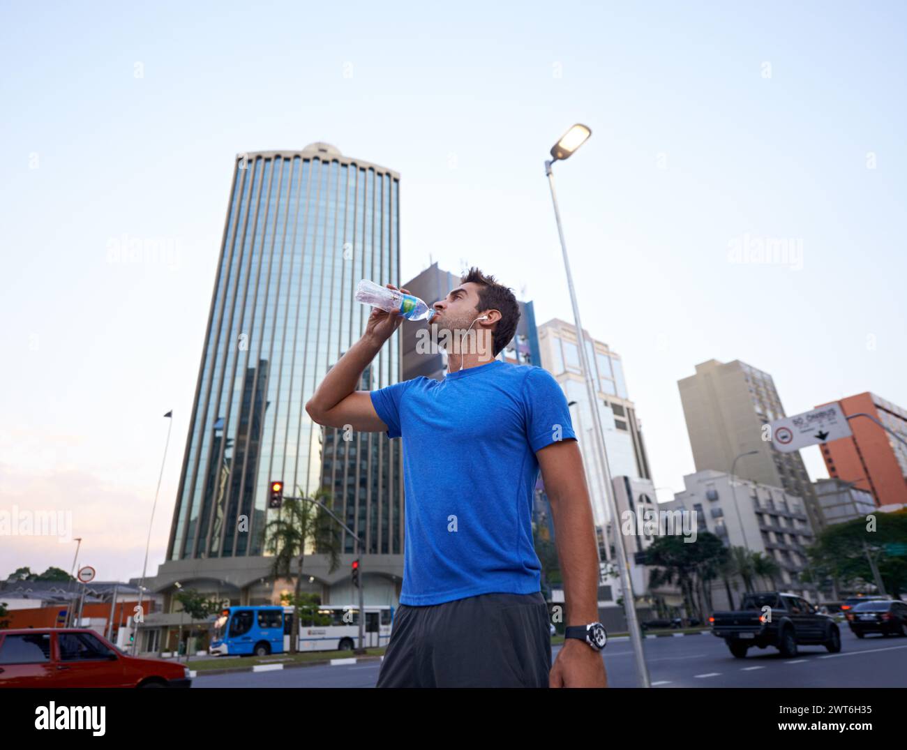 Hydration, break and man drinking water in city for exercise, running ...