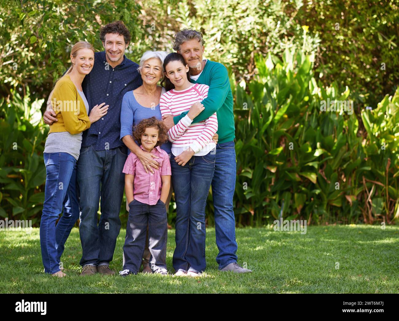 Family, portrait and hug in outdoor nature, love and bonding together ...