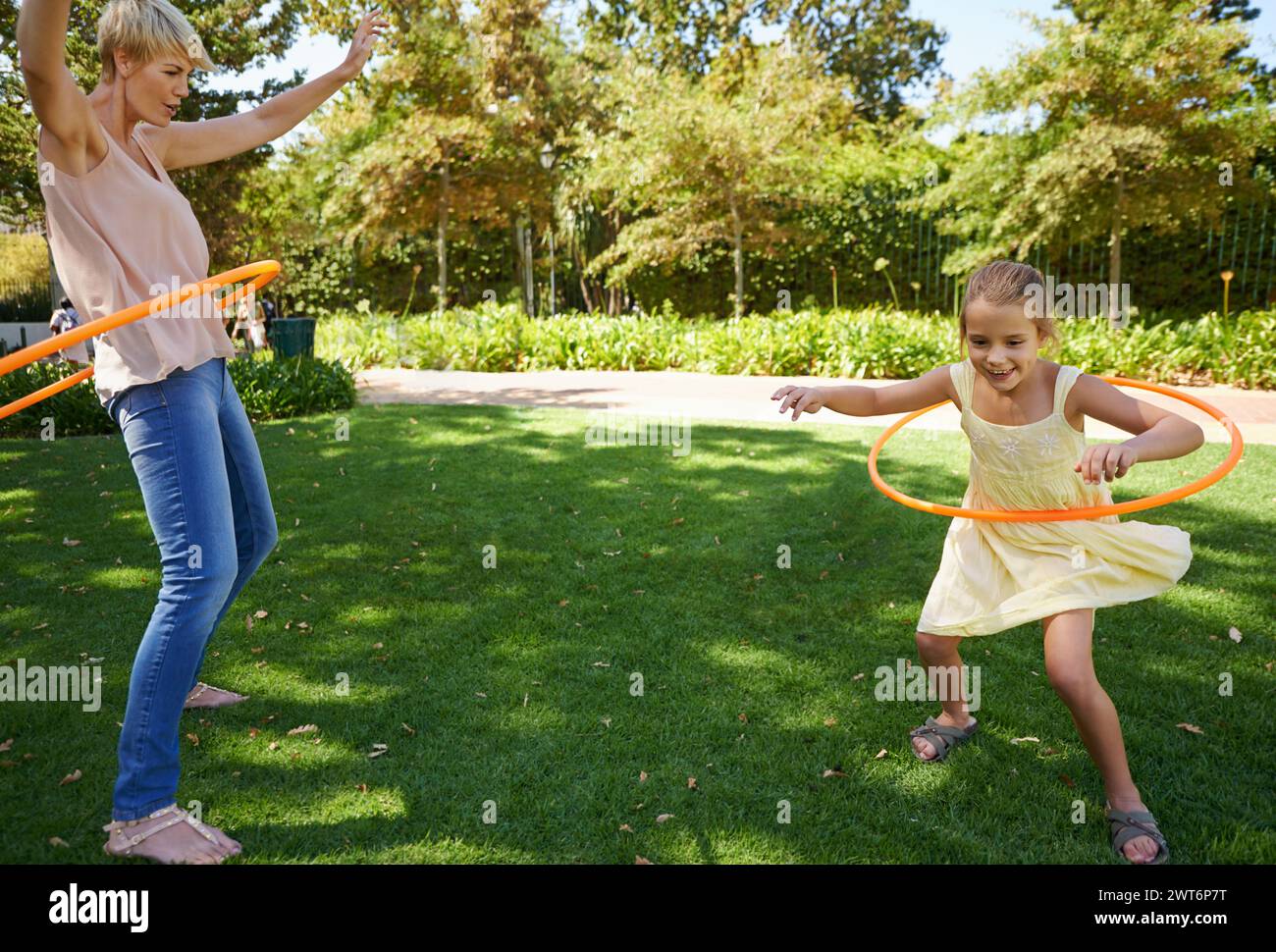 Mother, child and hula hoop for outdoor fun in backyard garden for ...