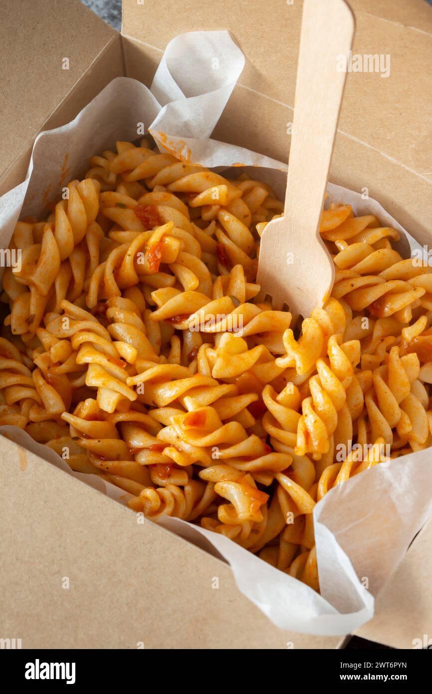 Fusilli pasta in a tomato and herb sauce takeaway in a cardboard box ...