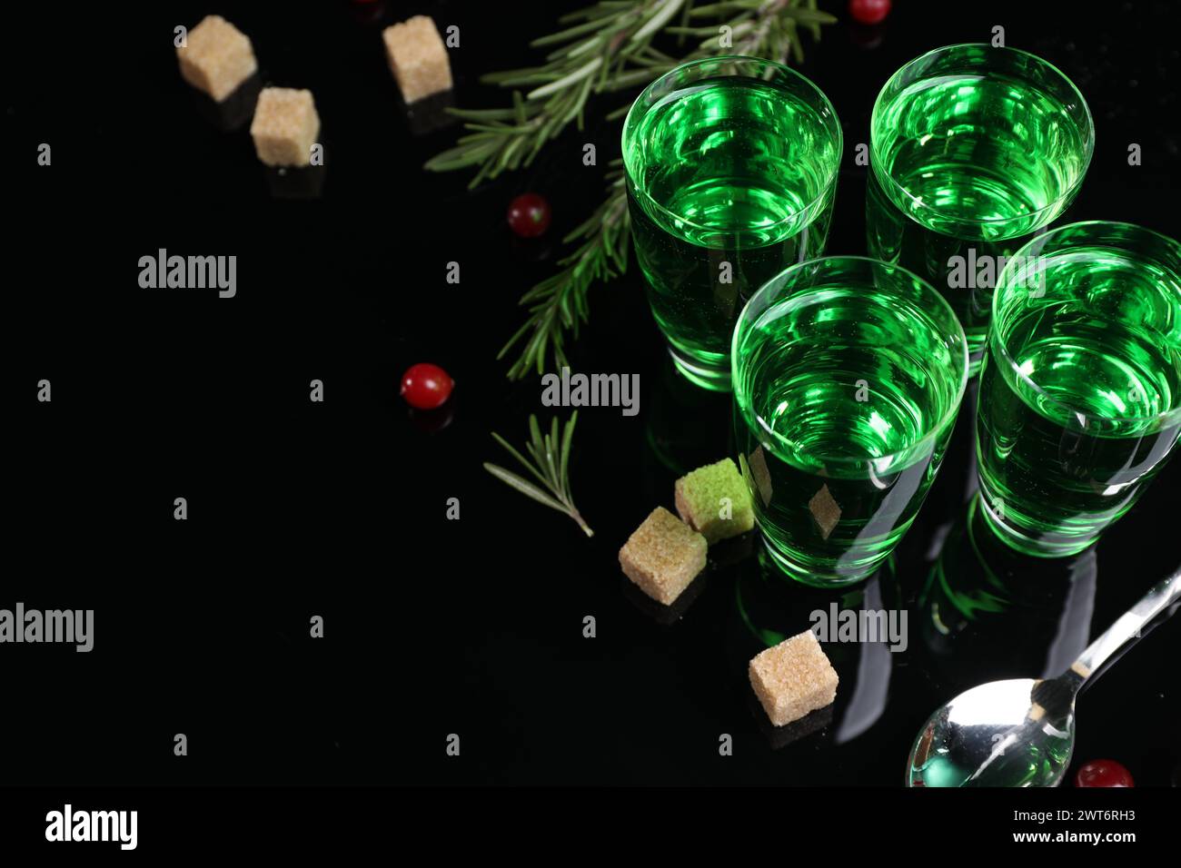 Absinthe in shot glasses, cranberries, rosemary and brown sugar on ...