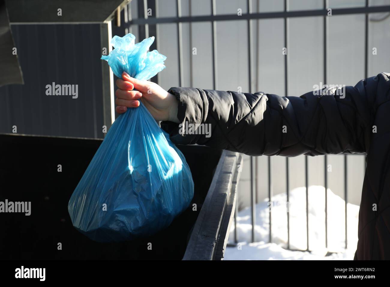 Woman throwing trash bag full of garbage in bin outdoors, closeup Stock ...