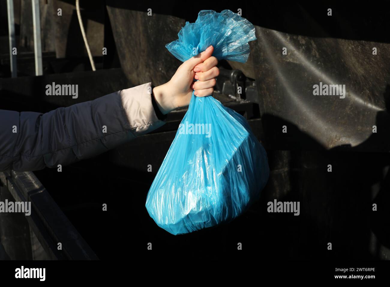 Woman throwing trash bag full of garbage in bin outdoors, closeup Stock ...