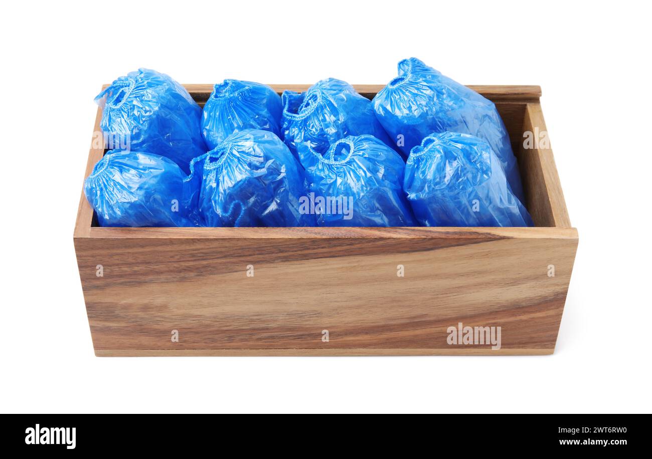 Rolled blue shoe covers in wooden crate isolated on white Stock Photo ...