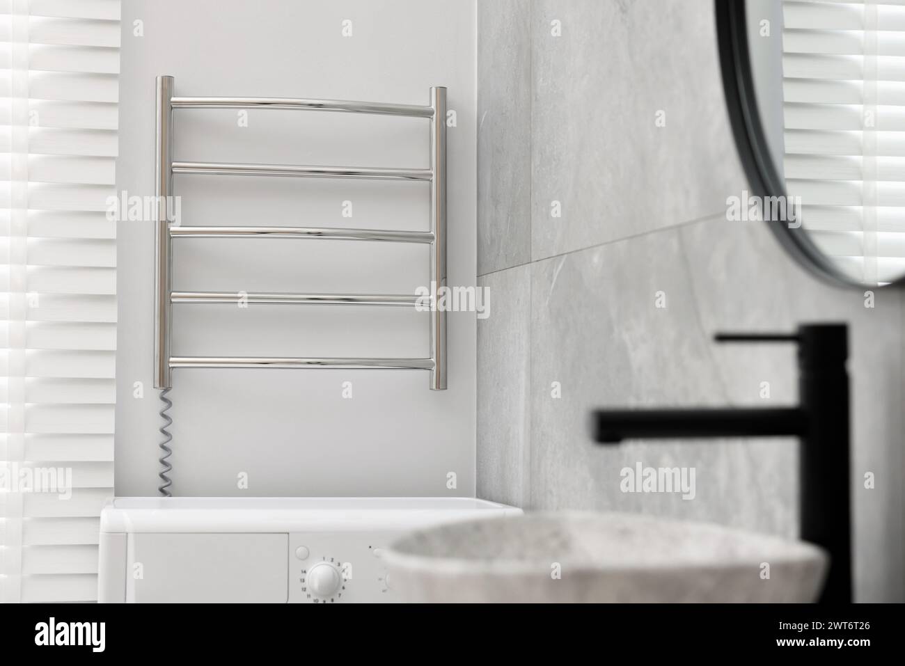 Modern heated towel rail on wall in bathroom Stock Photo - Alamy