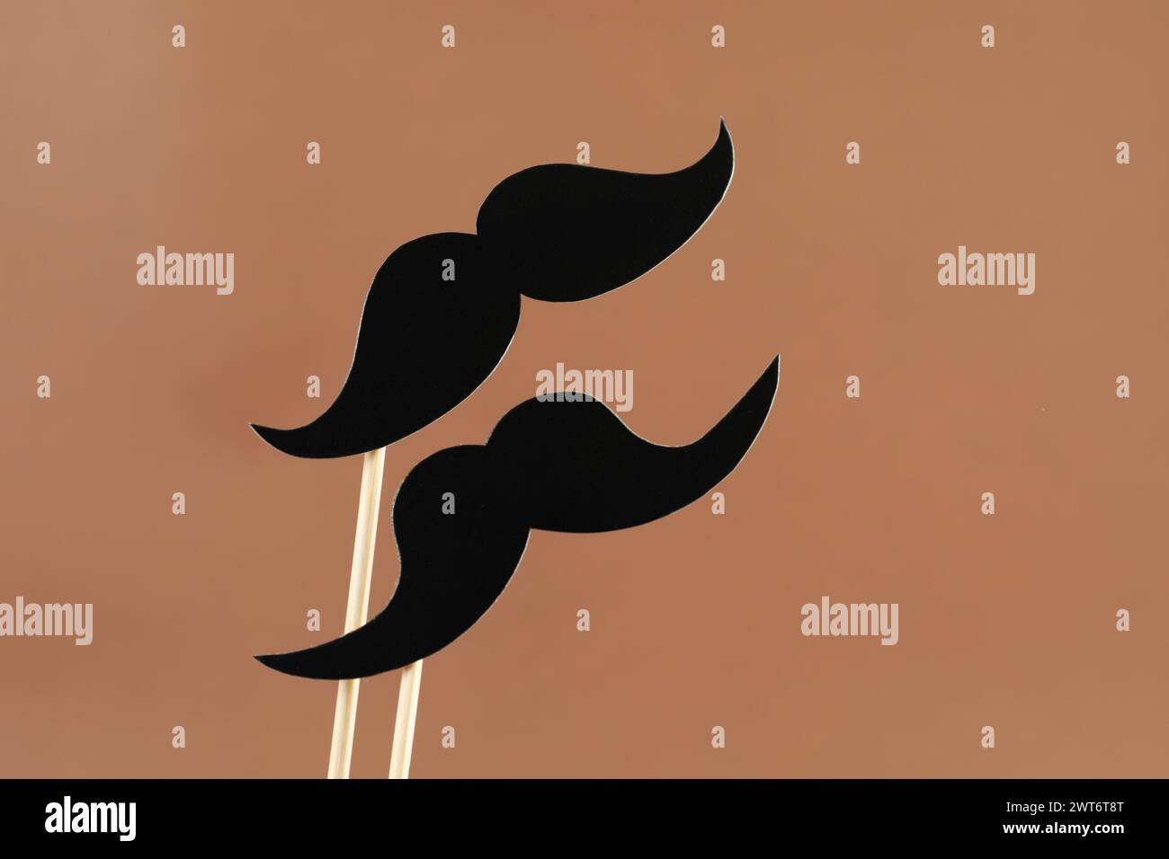 Fake paper mustaches party props on light brown background Stock Photo ...