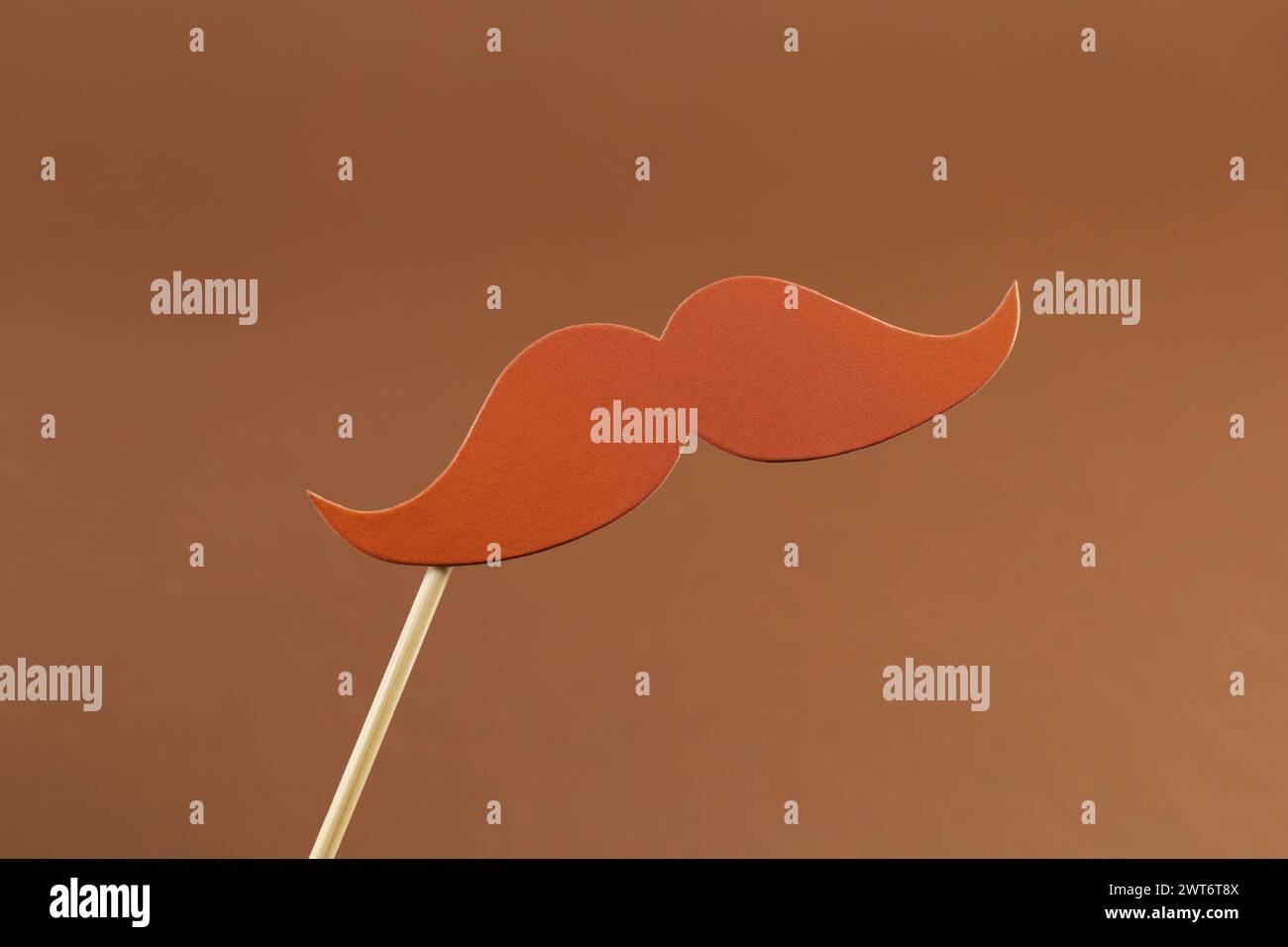 Fake paper mustache party prop on light brown background Stock Photo ...