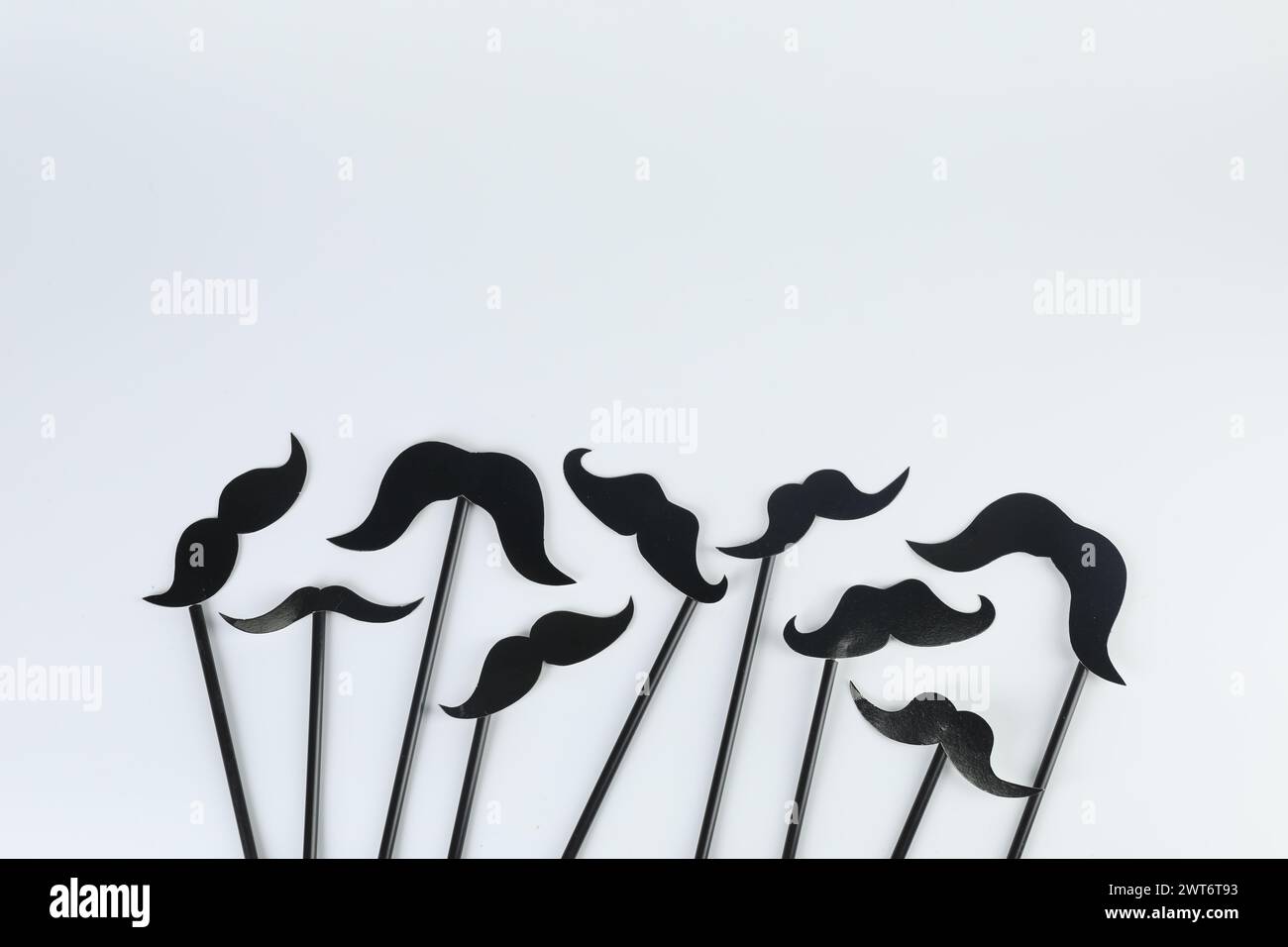 Fake paper mustaches party props on light background, flat lay. Space ...