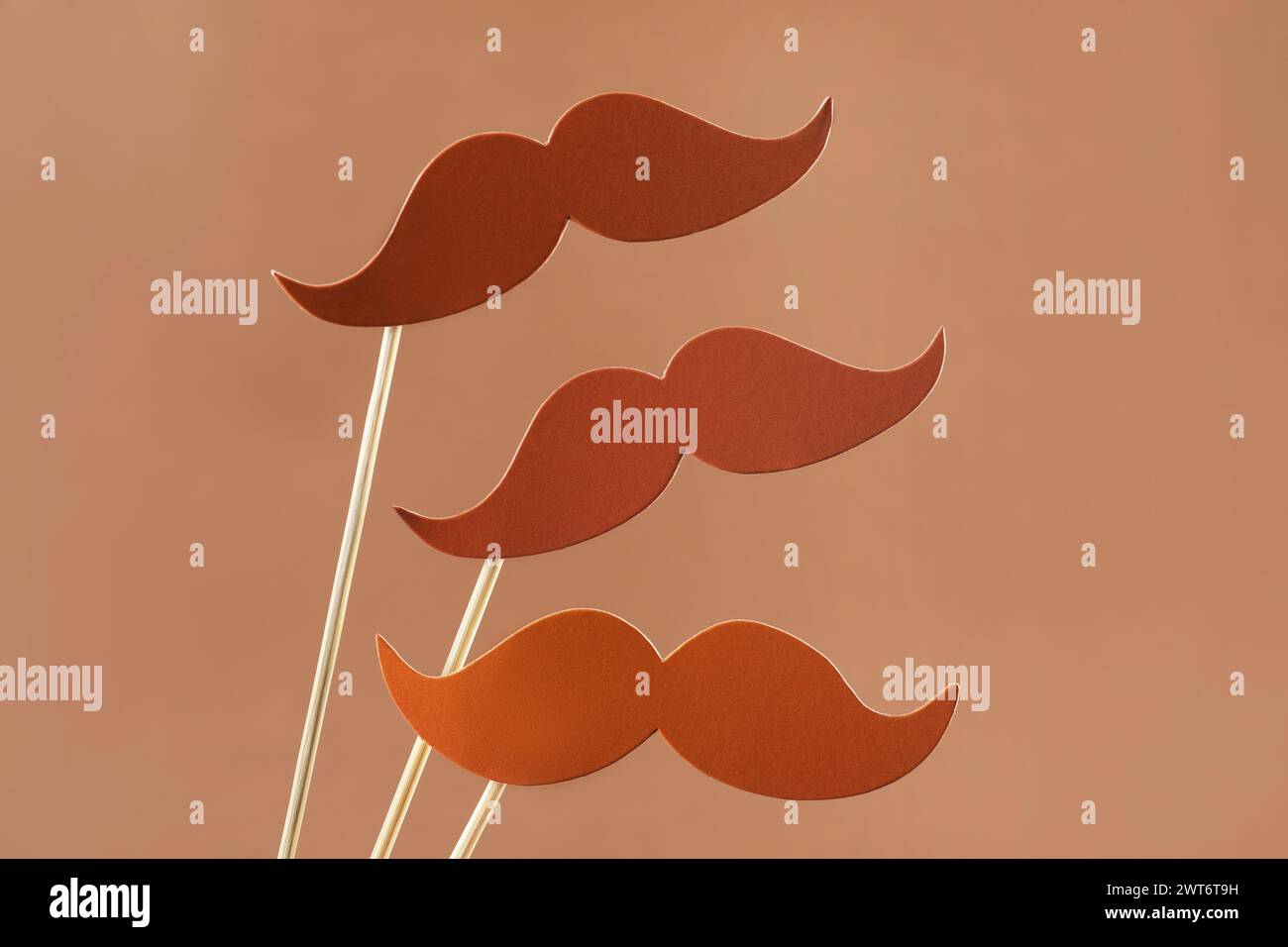 Fake paper mustaches party props on light brown background Stock Photo ...