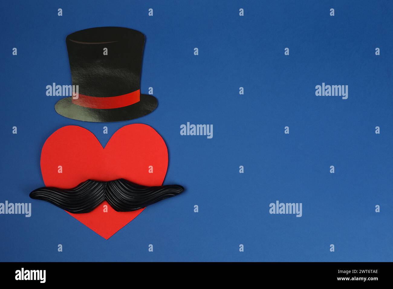 Fake mustache, paper hat and heart on blue background, top view. Space ...