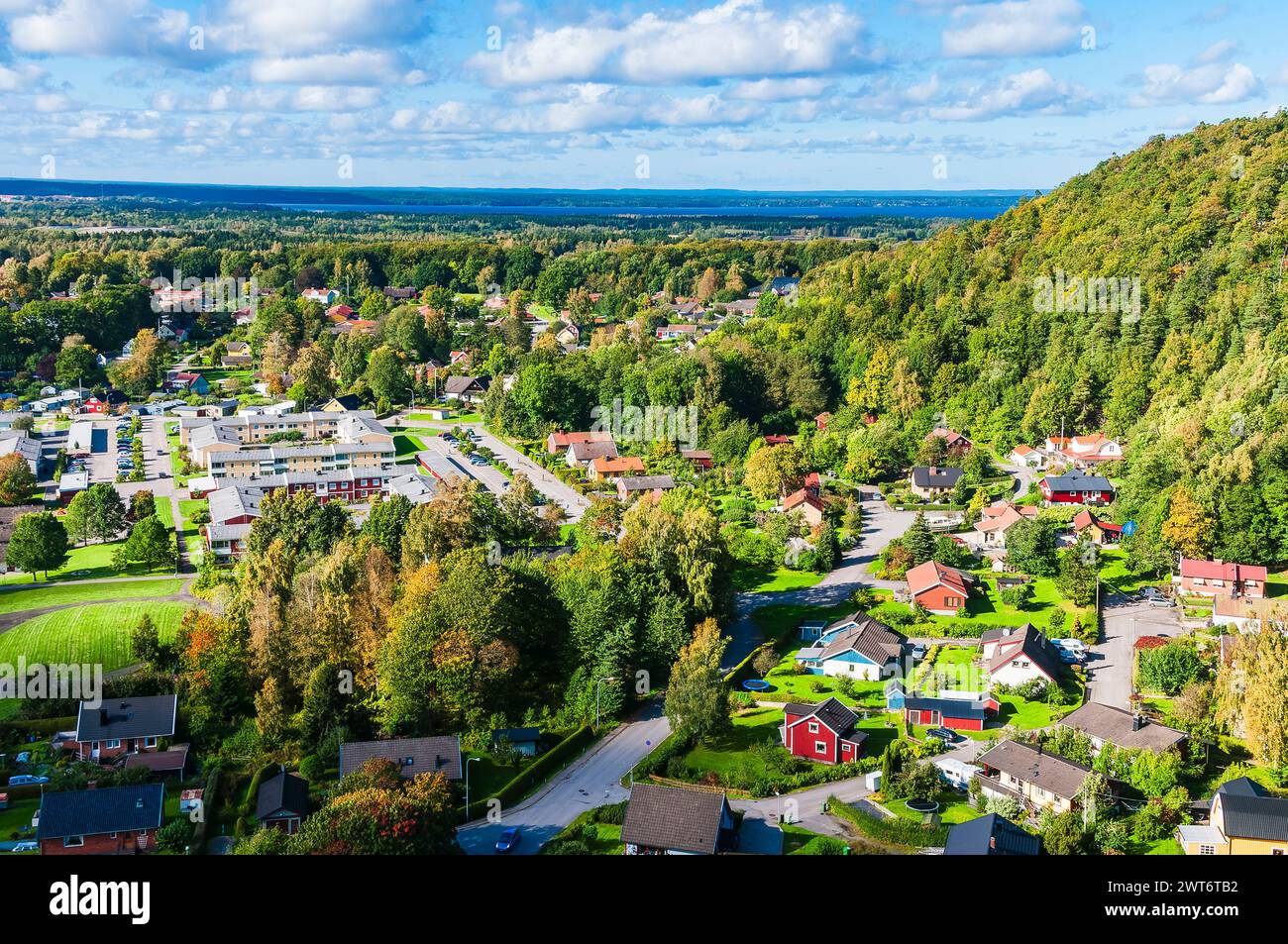 An aerial perspective of a town nestled amidst a dense array of trees ...