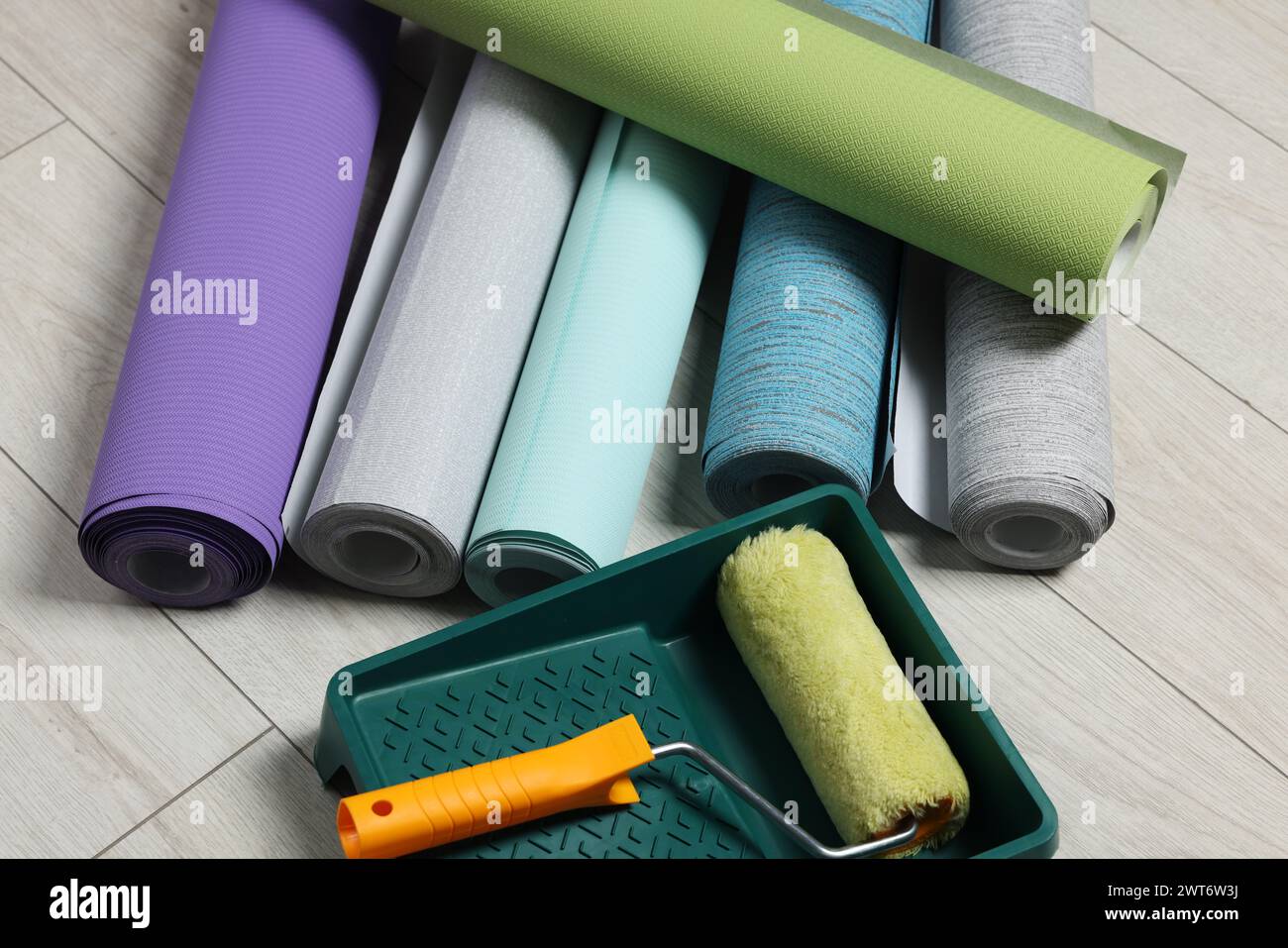 Different wallpaper rolls, roller and tray on floor Stock Photo - Alamy