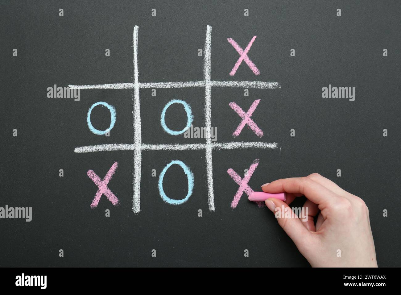 Woman playing tic tac toe on chalkboard, closeup Stock Photo - Alamy