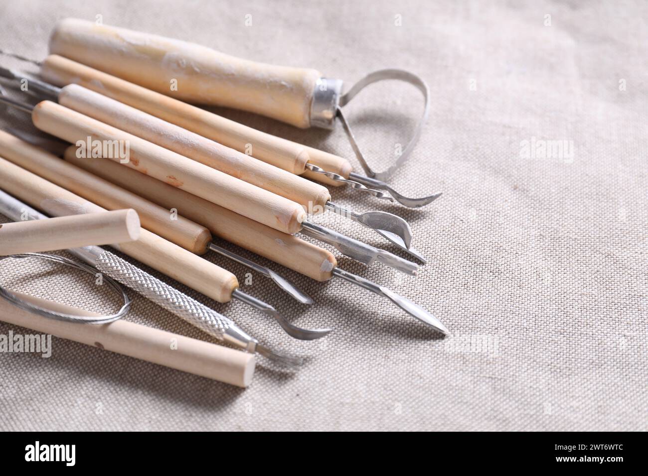 Set of different clay crafting tools on grey fabric, closeup. Space for ...