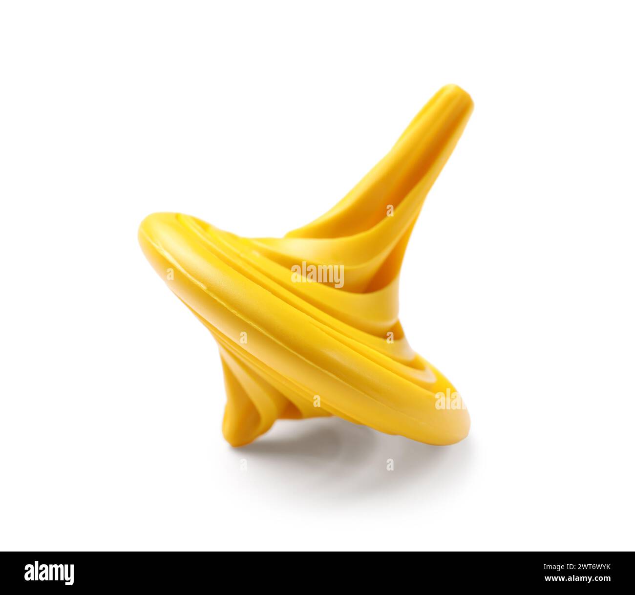 One yellow spinning top on white background Stock Photo - Alamy