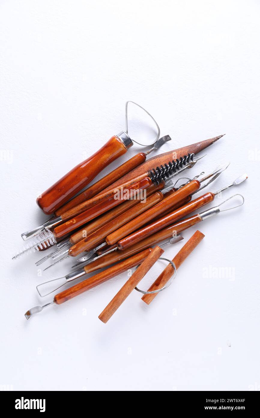 Set of different clay crafting tools on white textured table, flat lay ...