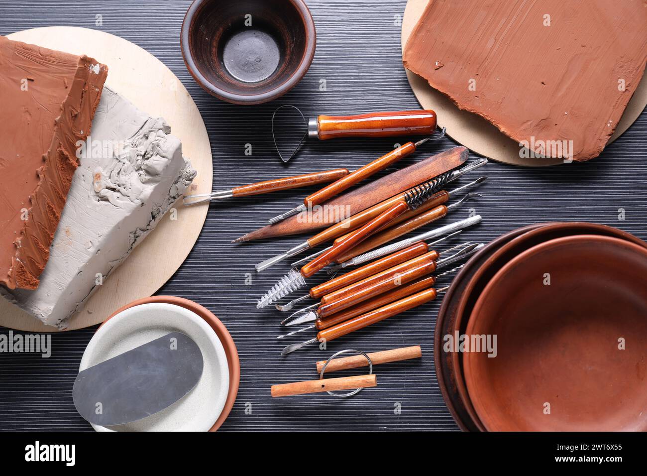 Clay, dishes and set of crafting tools on black table, flat lay Stock ...