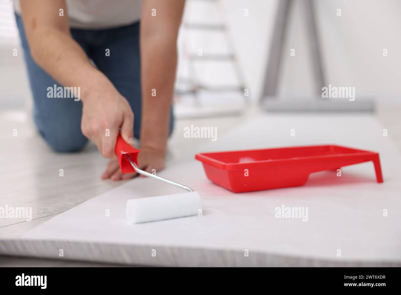 Man applying glue onto wallpaper sheet in room, closeup Stock Photo - Alamy
