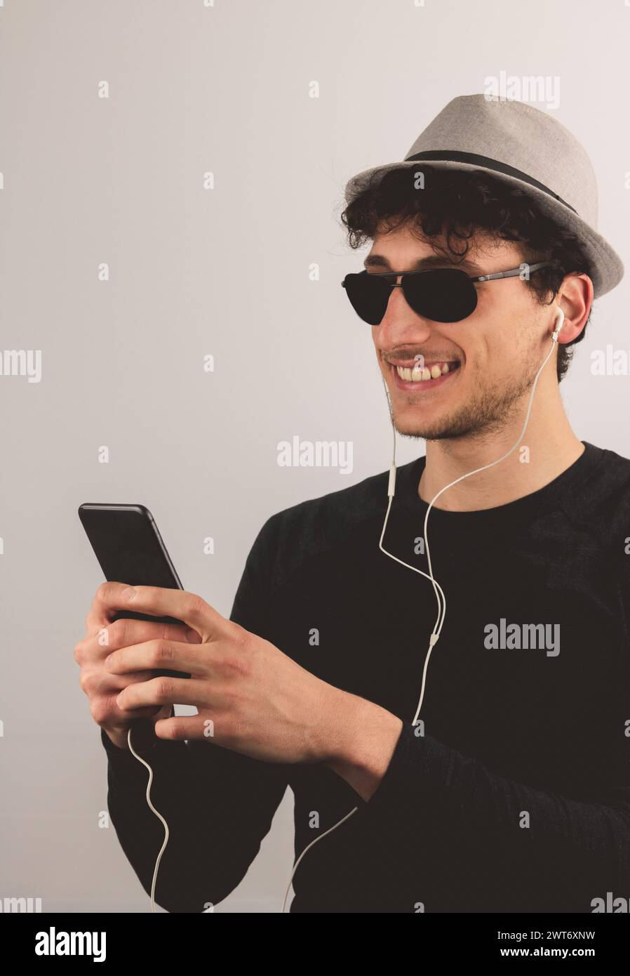 portrait of cheerful and confidential teenager smiling looking mobile ...