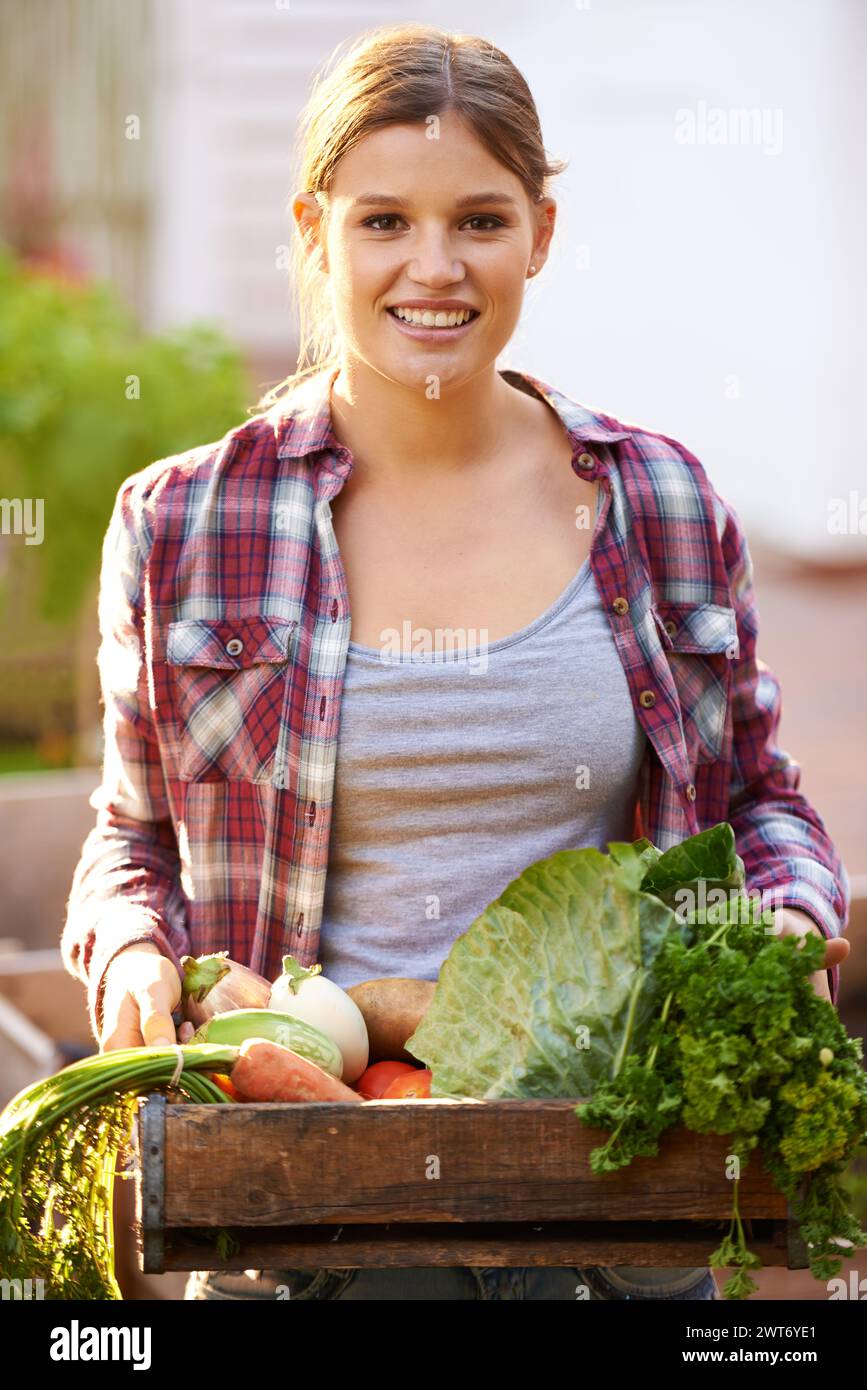 Happy woman, portrait and harvester with box of vegetables from garden ...