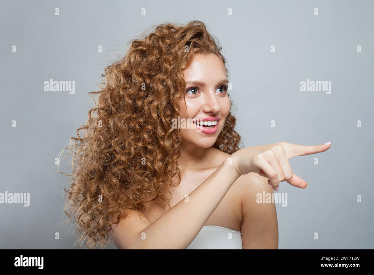 Attractive woman pointing finger. Beautiful female model with natural ...