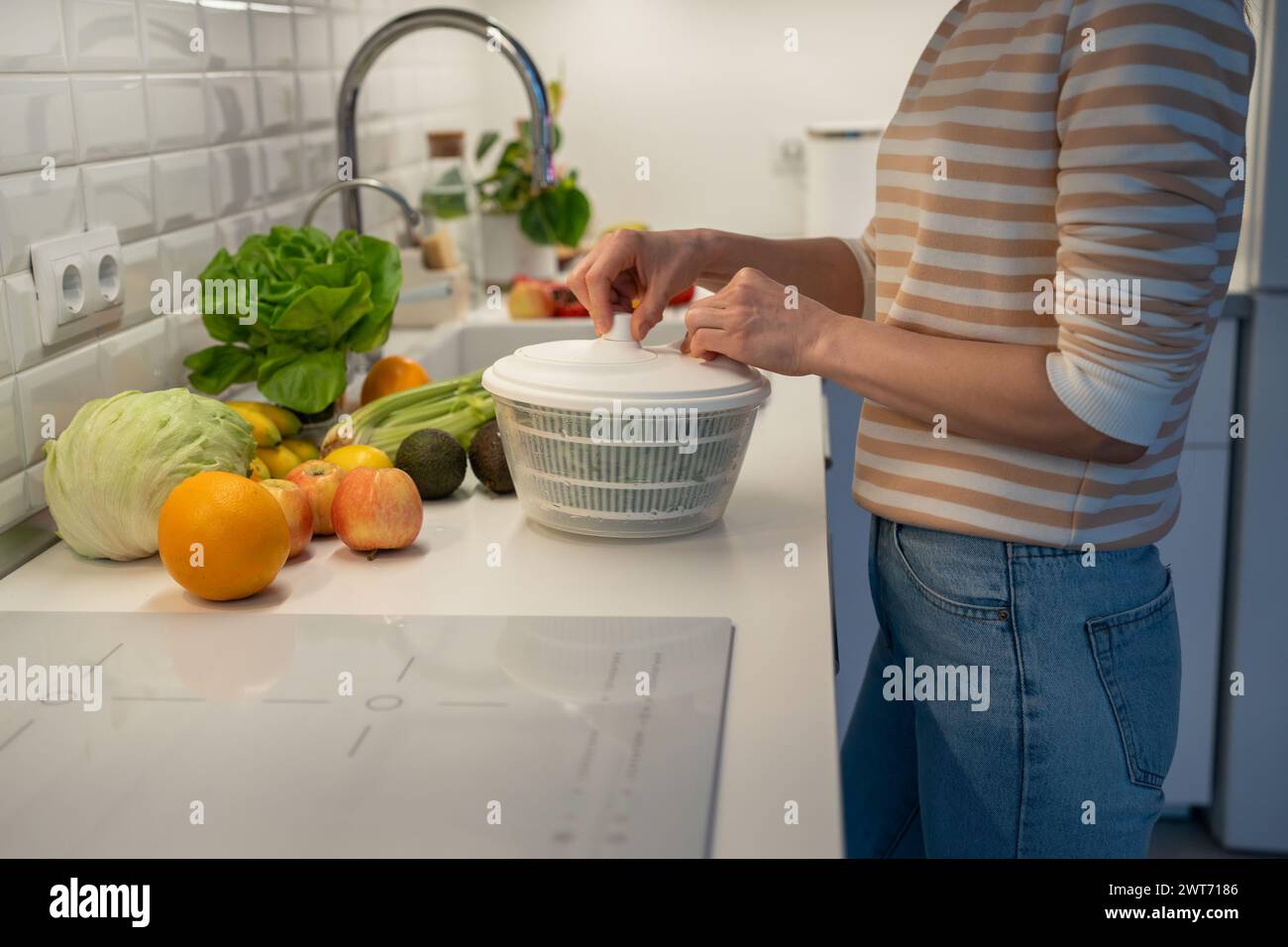Slender female on diet cooking quick fresh healthy salad by drying ...