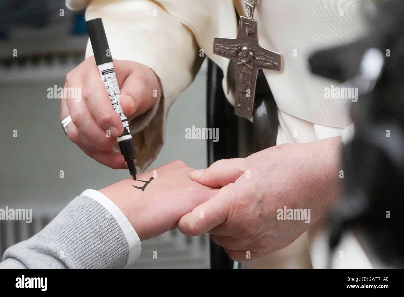 Pope Francis signs with his initial the hand of a patient as he meets ...