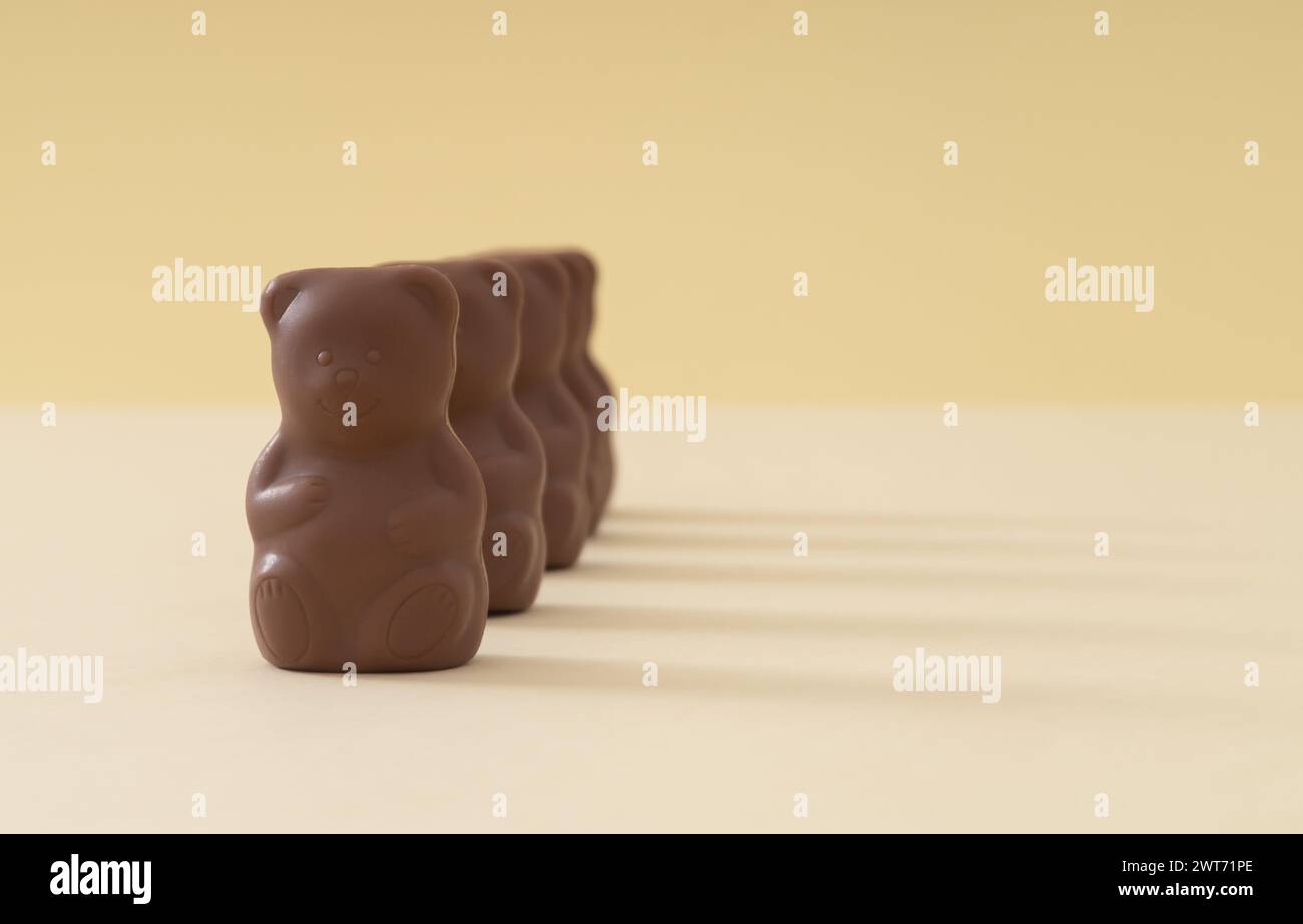 Creative arrangement made with chocolate teddy bears on pastel cream ...