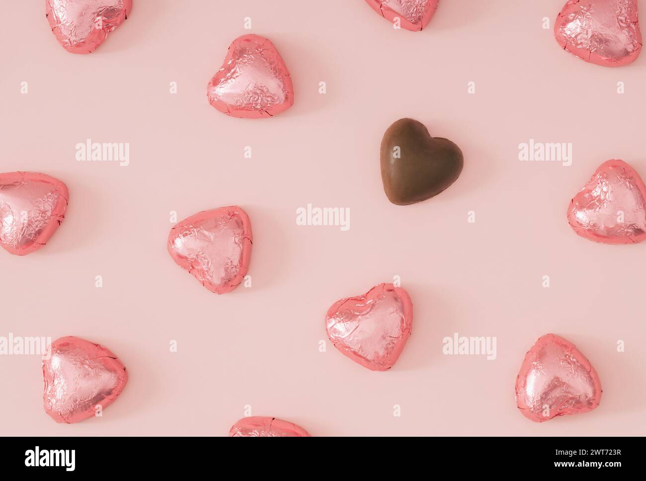 Romantic pattern composition made with foil wrapped pink chocolate ...