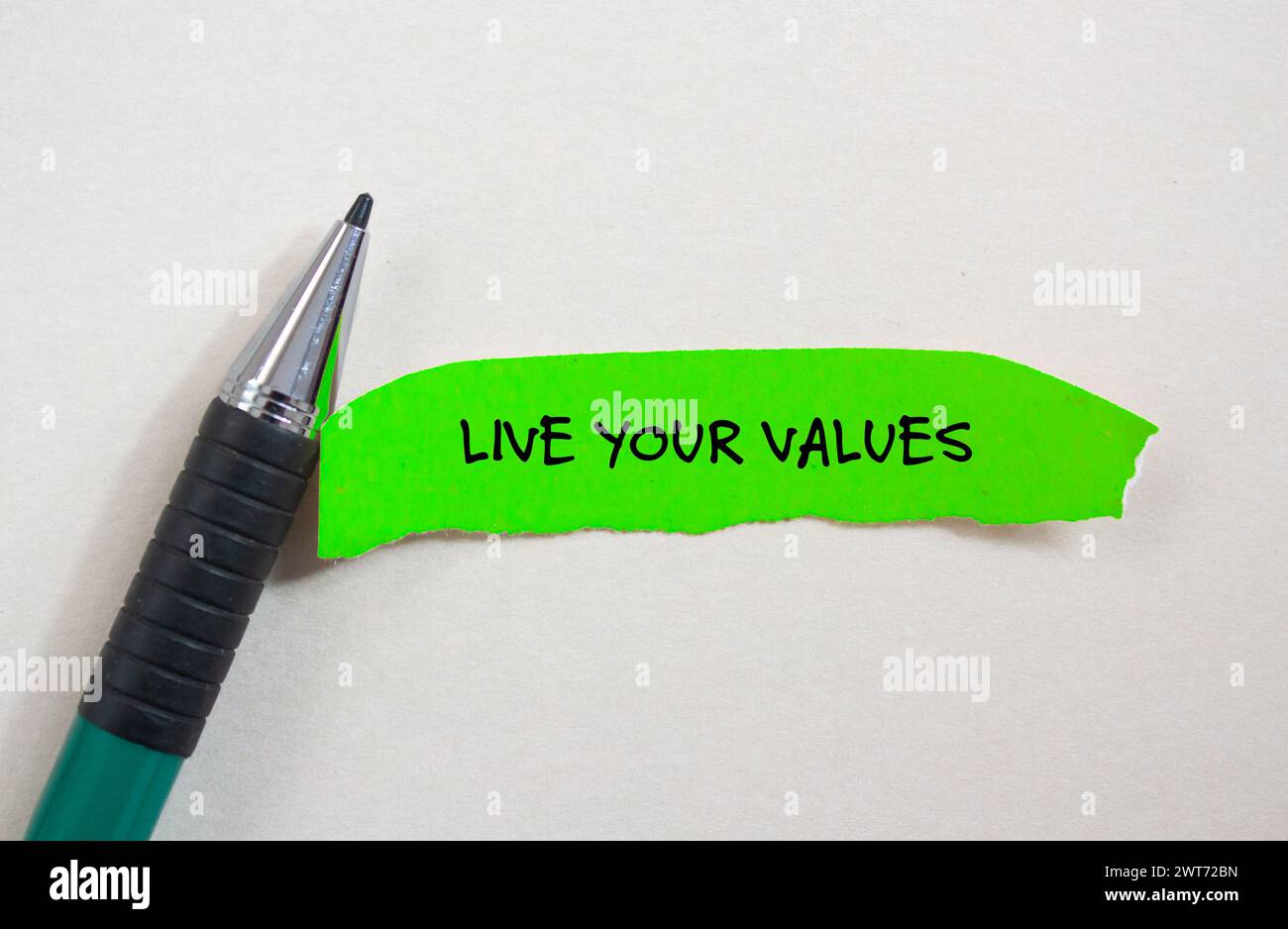 Live your values words written on green torn paper piece with white ...