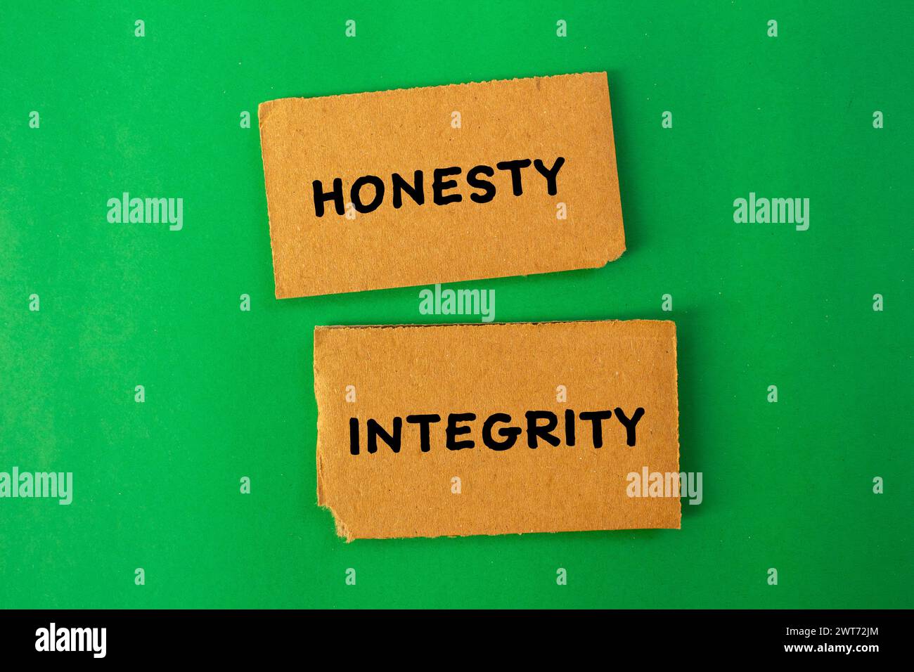 Honesty and integrity words written on torn paper pieces with green ...