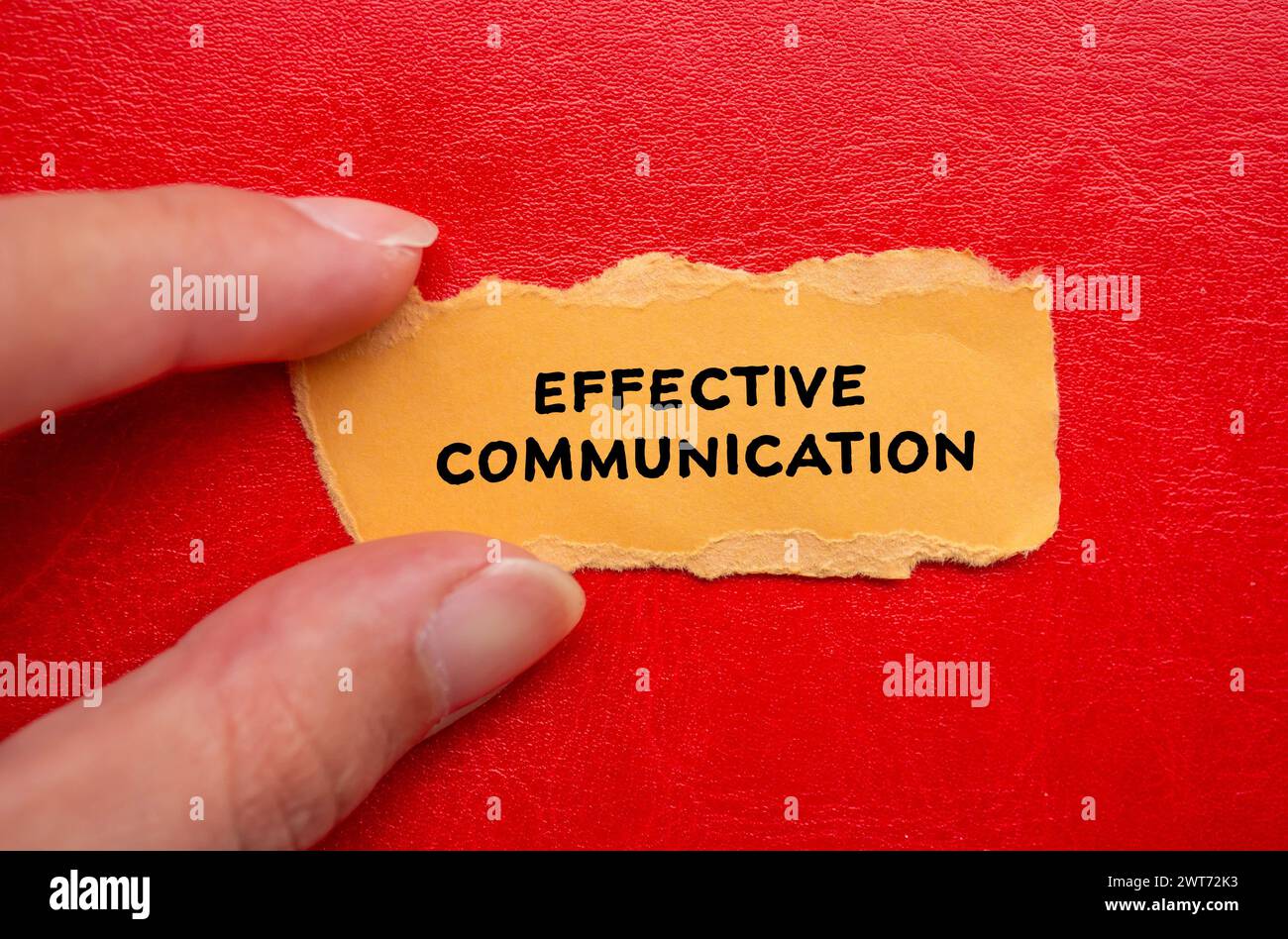 Effective communication words written on orange torn paper piece with ...
